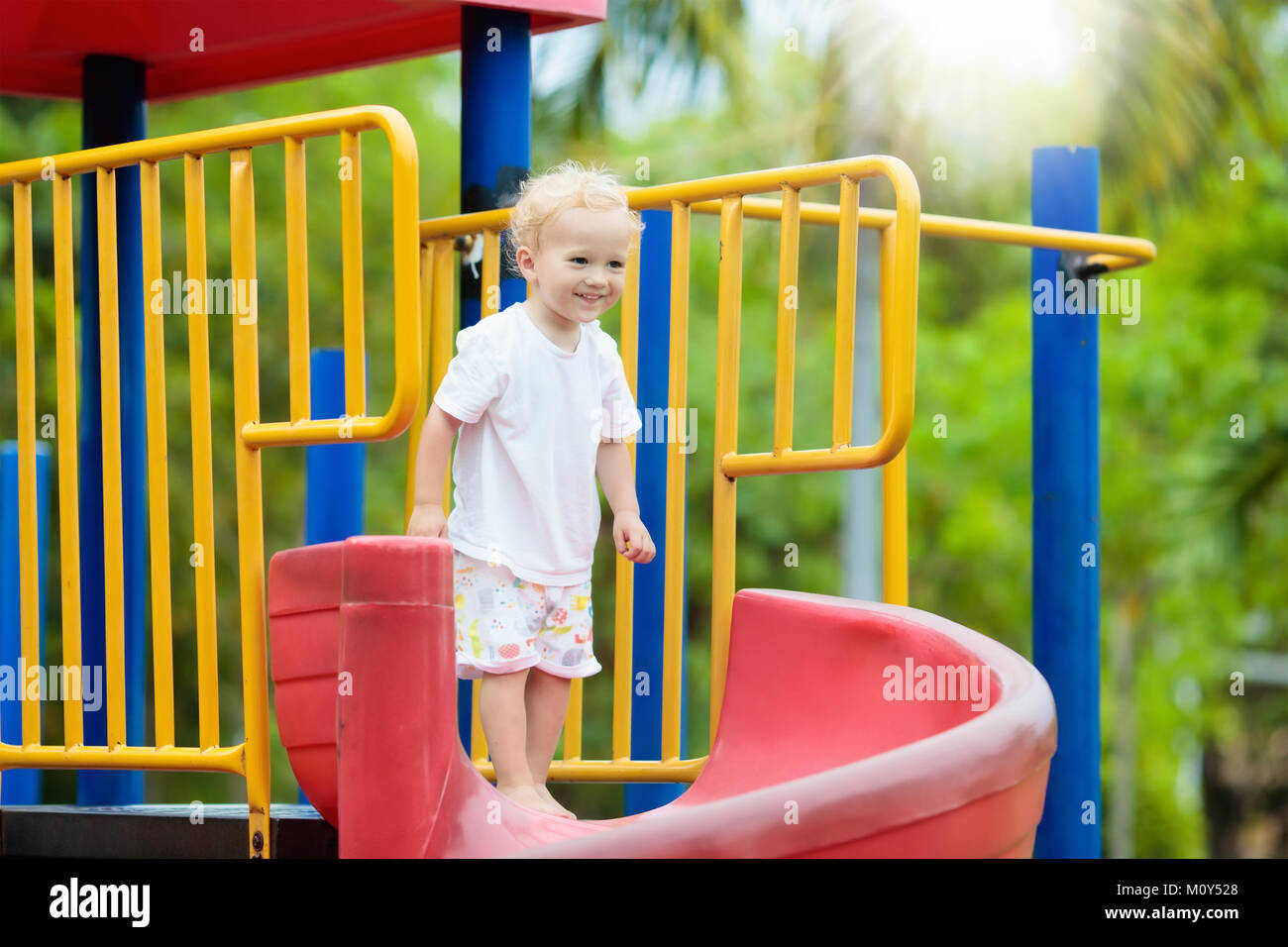 Kids on climbing and sliding on outdoor playground. Children play in ...