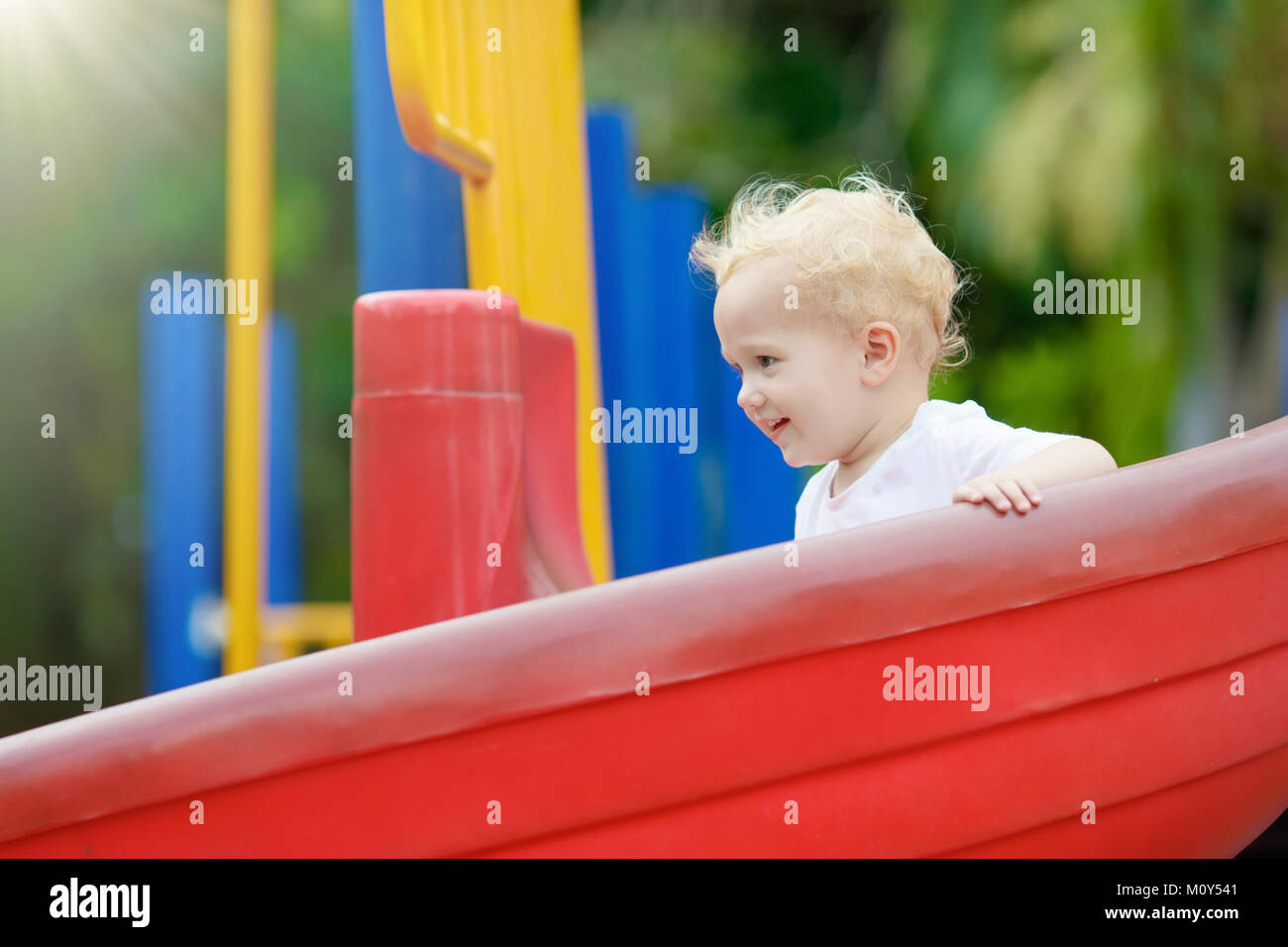 Kids on climbing and sliding on outdoor playground. Children play in ...
