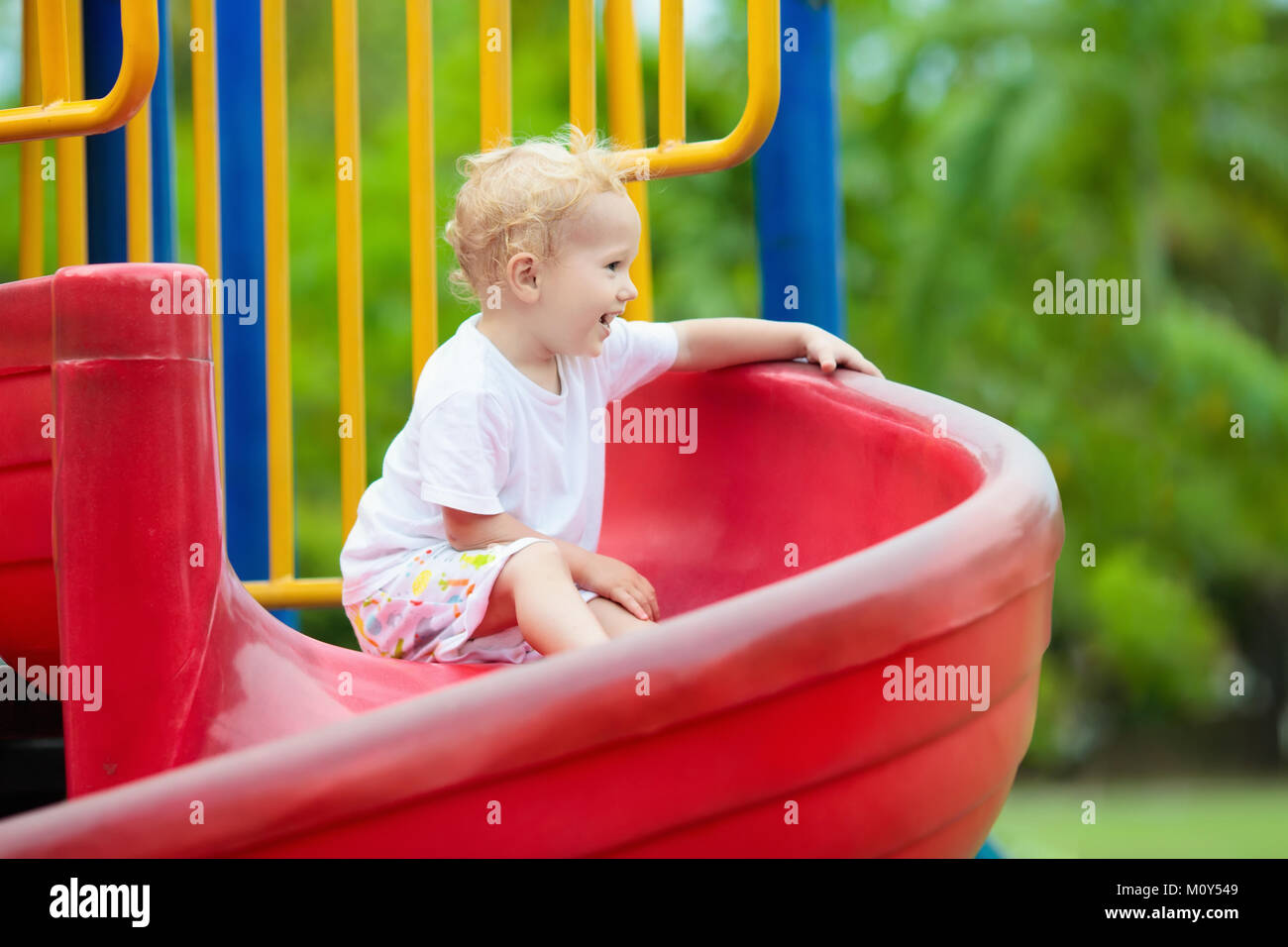 Kids on climbing and sliding on outdoor playground. Children play in ...