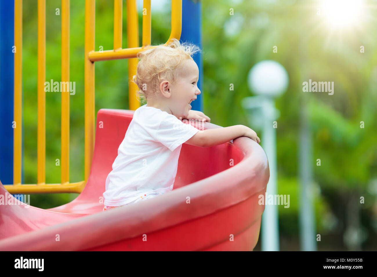 Kids on climbing and sliding on outdoor playground. Children play in ...