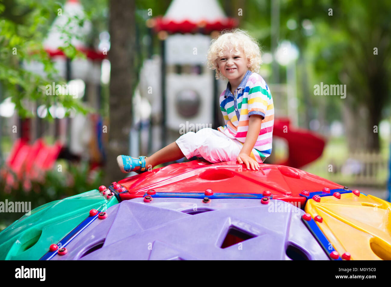 Kids on playground. Children play in summer park. Child on slide and ...