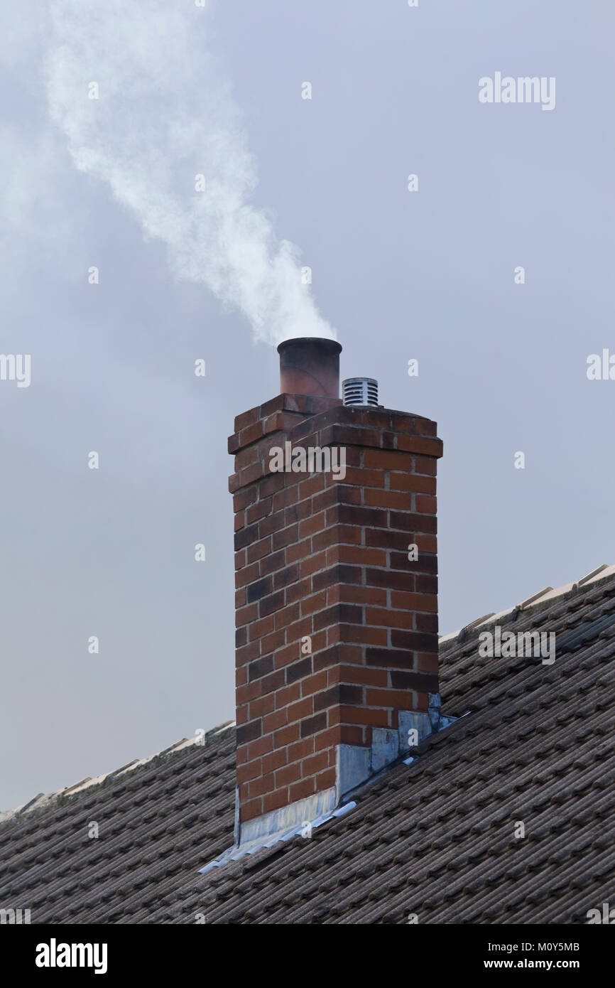 Chimney stack on domestic house with white smoke billowing from the ...