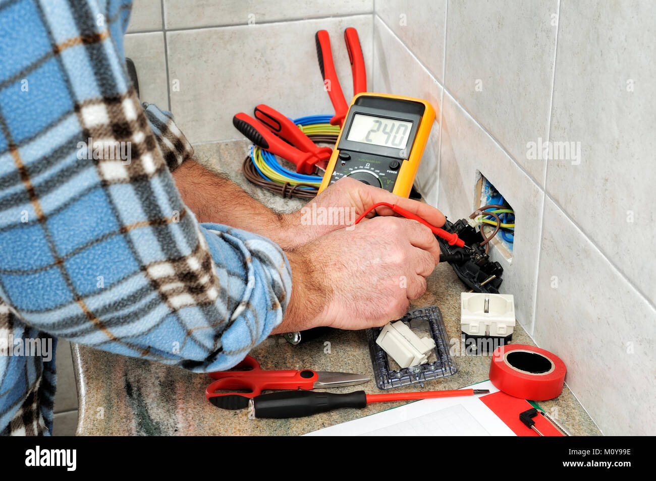 Electrician technician at work measures the voltage of a residential ...
