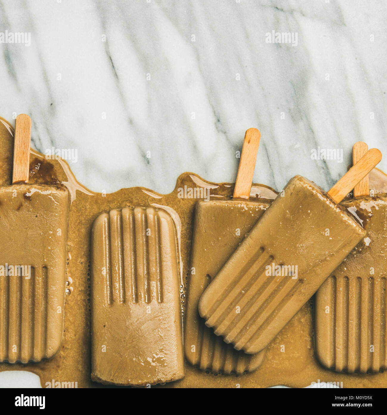 Summer healthy vegan frozen dessert. Flatlay of melting coffee latte ...