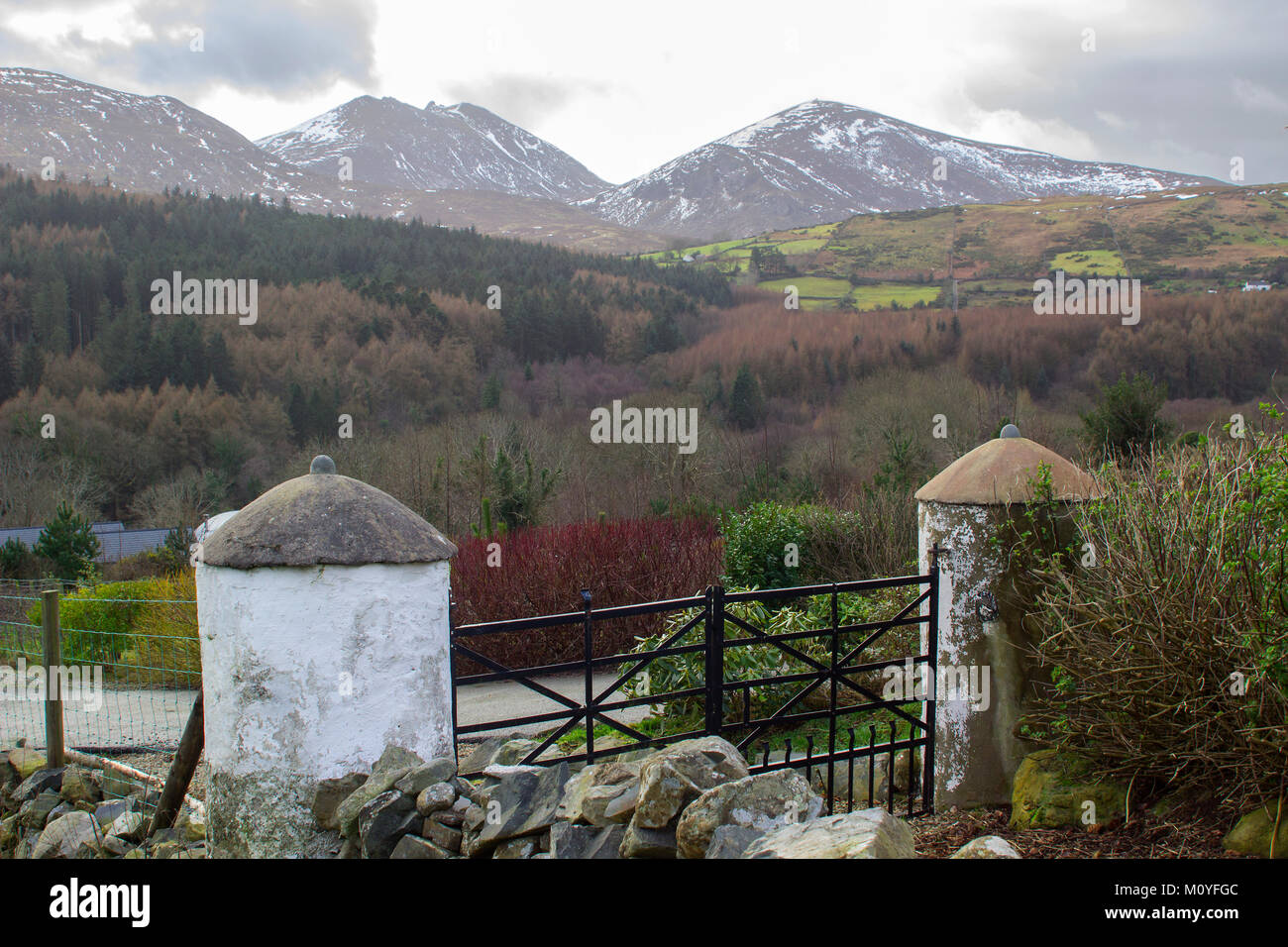 A view from a farm gate across on of the many snow topped hills and ...