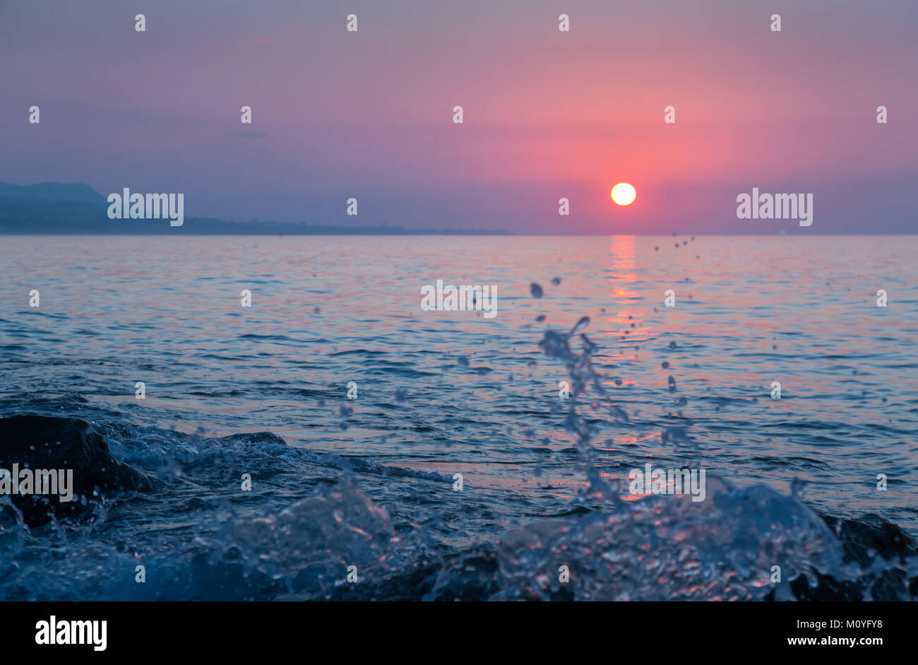sunrise view of Mediterranean sea with sun and splashes Stock Photo - Alamy