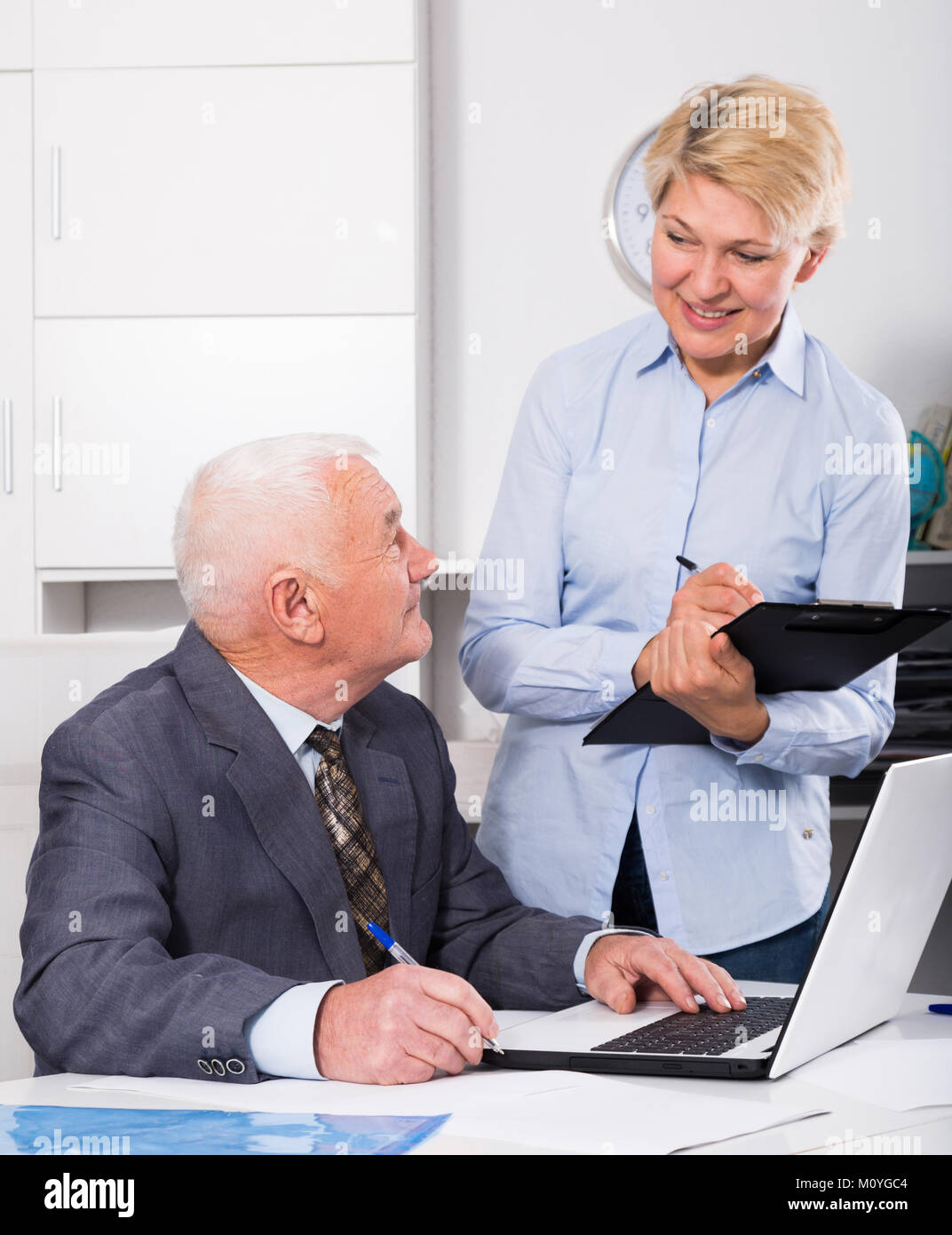 Senior manager and secretary working effectively together in office ...