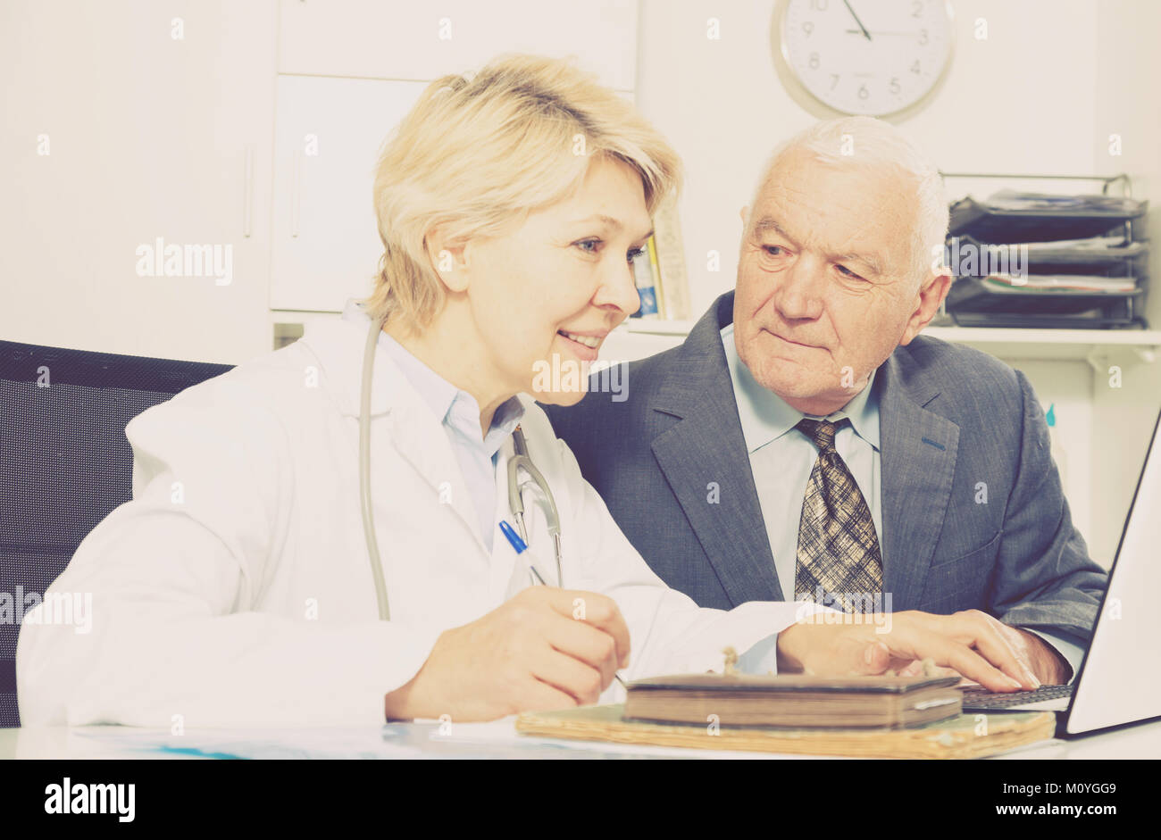 Mature male client visiting consultation with woman doctor in hospital ...