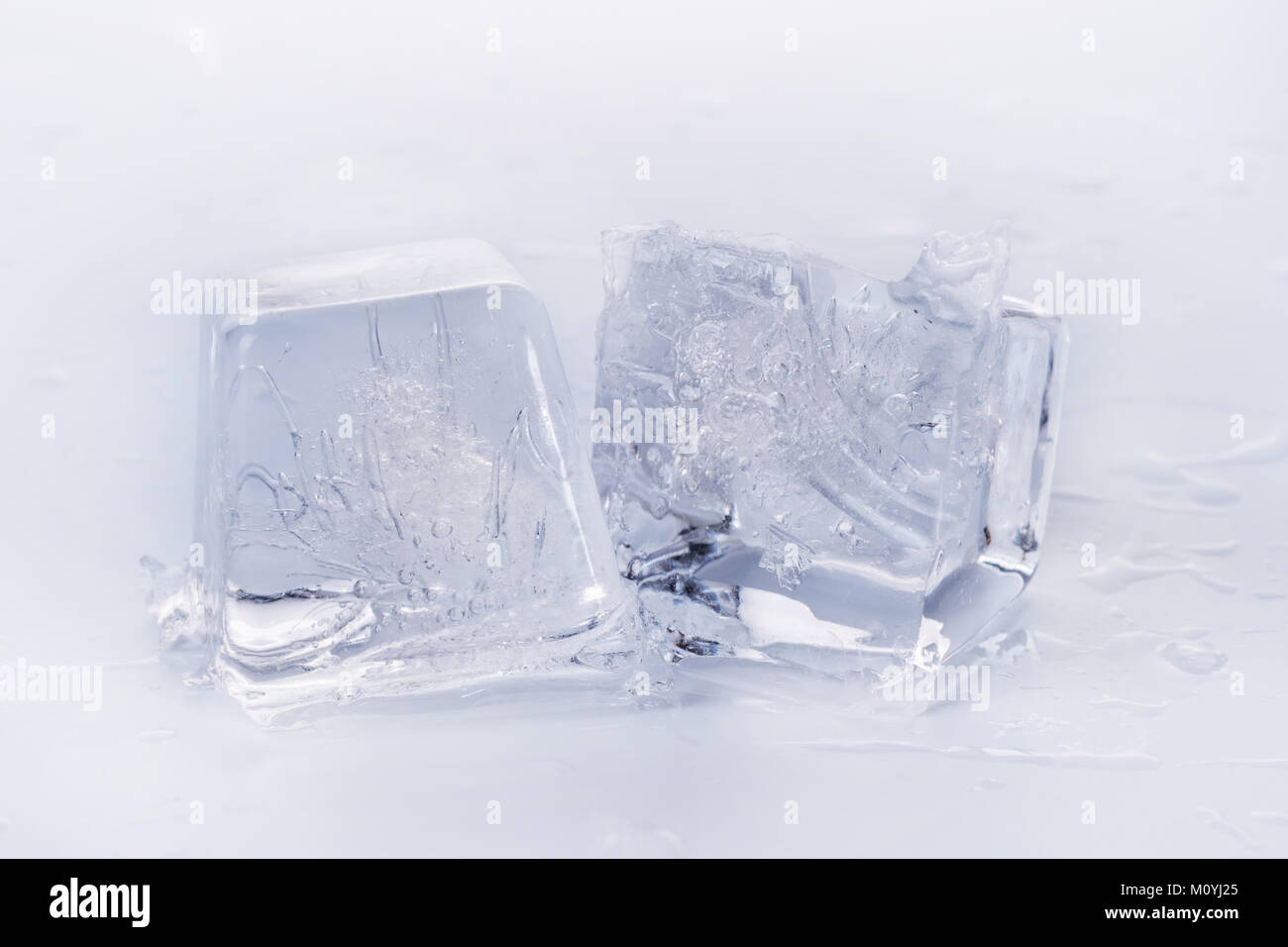 Two ice cubes on wet white surface Stock Photo - Alamy