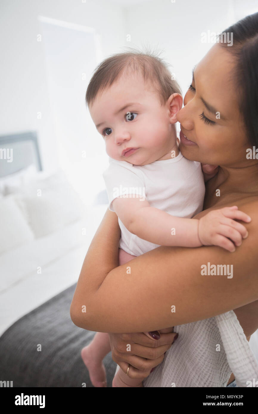 Mother hugging baby son in bedroom Stock Photo - Alamy