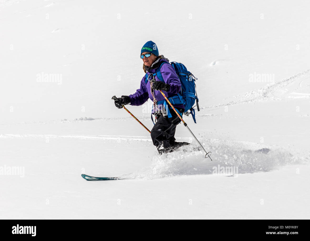 Female alpine telemark ski mountaineer skiing downhill in Antarctica ...