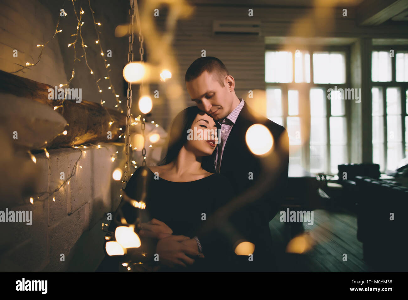 Caucasian couple hugging near wall Stock Photo - Alamy