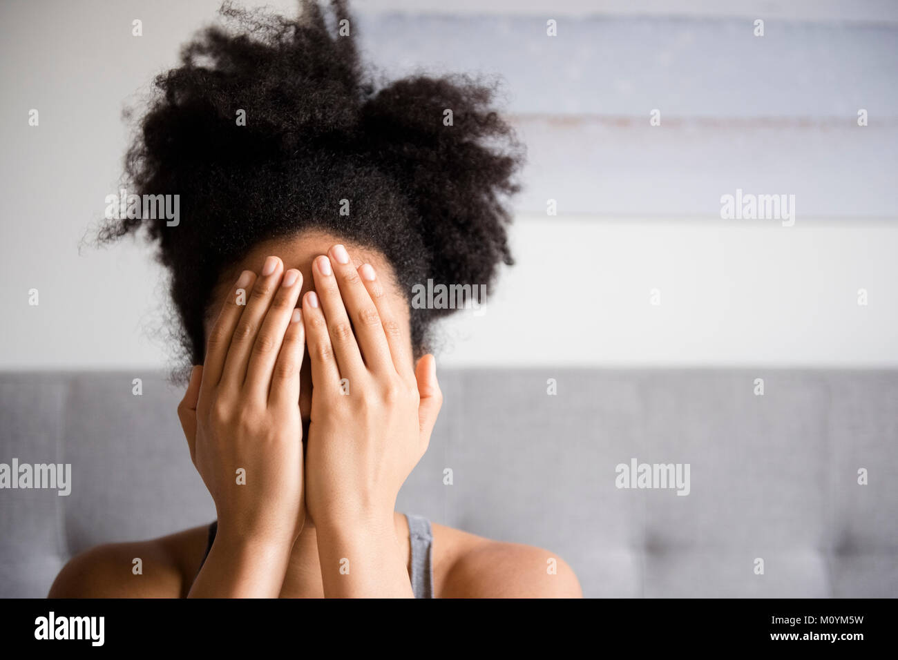 African American woman covering face with hands Stock Photo - Alamy