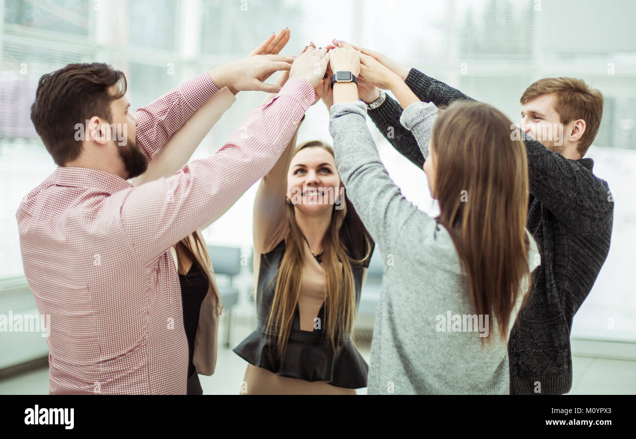 concept of teamwork:friendly business team standing in a circle and ...