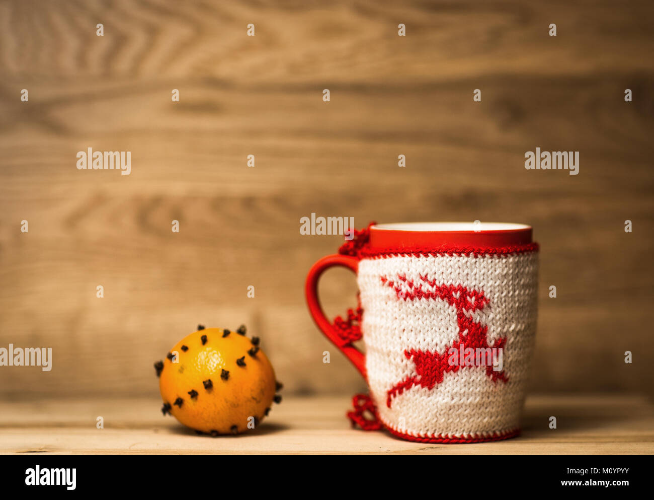 insulated wool cloth mug with embroidered deer in the wooden table with ...