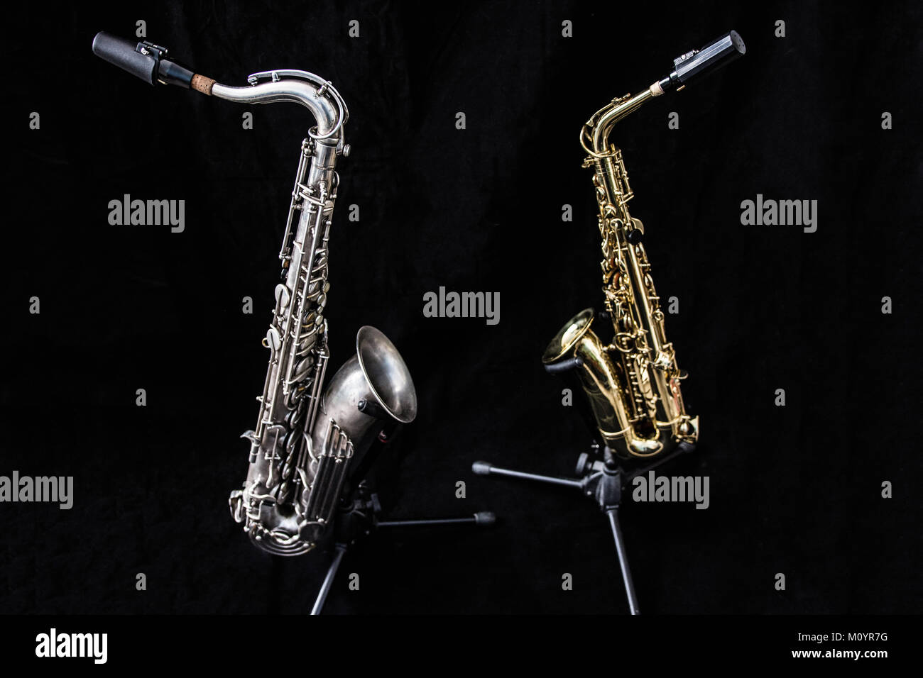 Full view of two saxophones standing isolated in black Stock Photo - Alamy