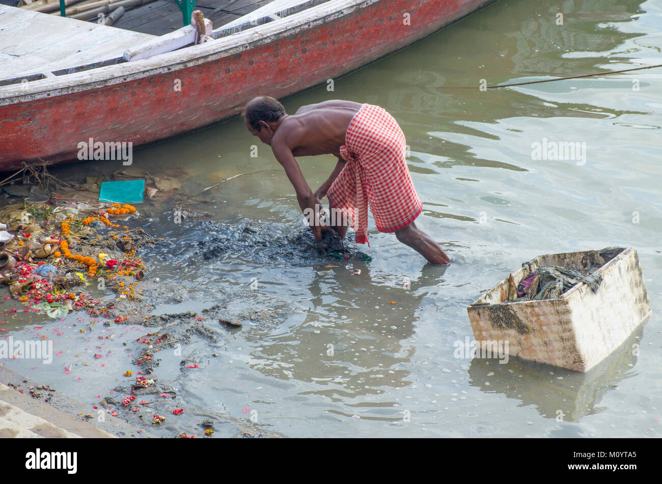 The man collects garbage in the Gang River India Stock Photo - Alamy