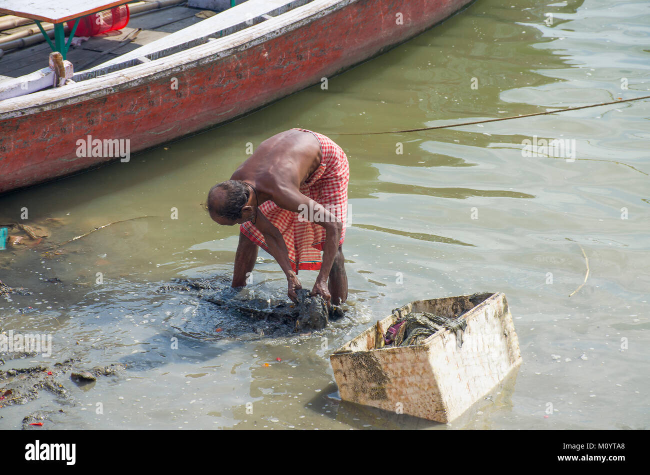 The man collects garbage in the Gang River India Stock Photo - Alamy