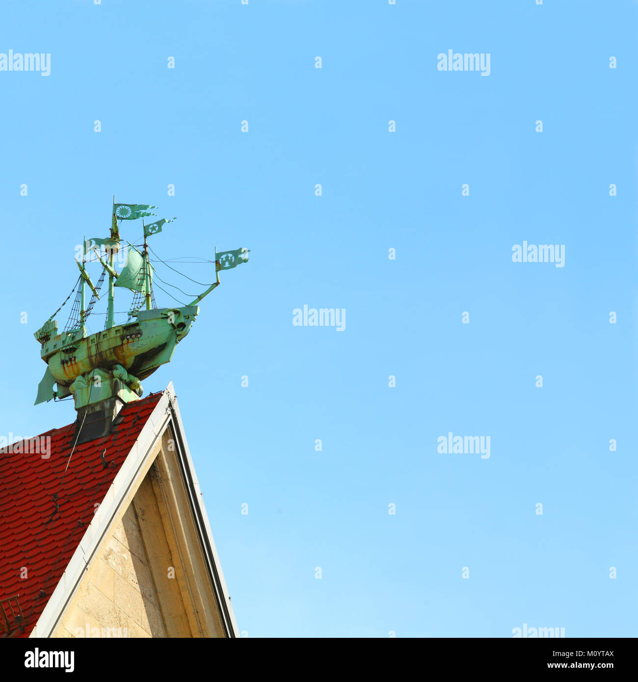 Travel concept - sailing ship against deep blue sky. Roof in old town ...