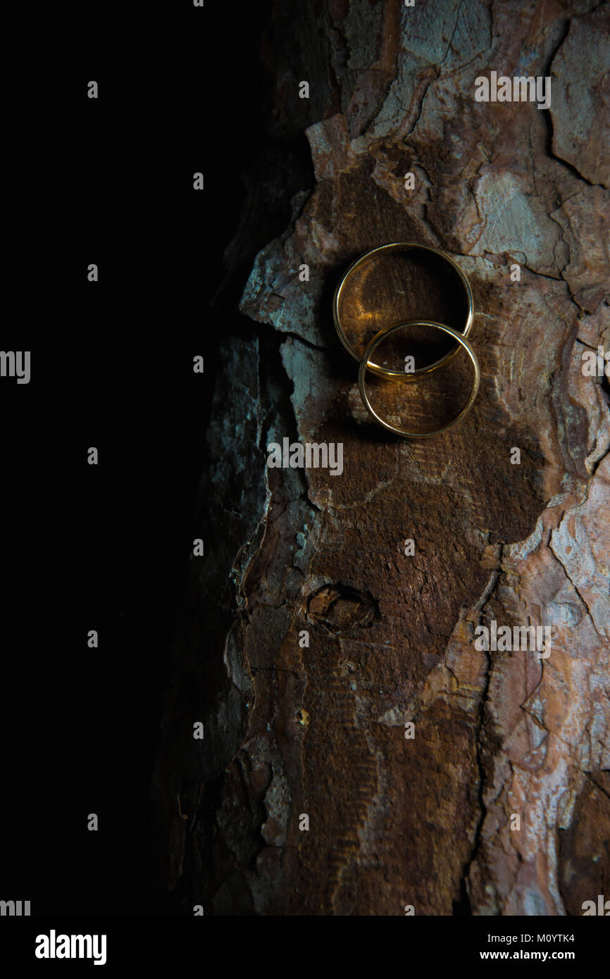 Two wedding rings on wooden background. Low key still life photography ...