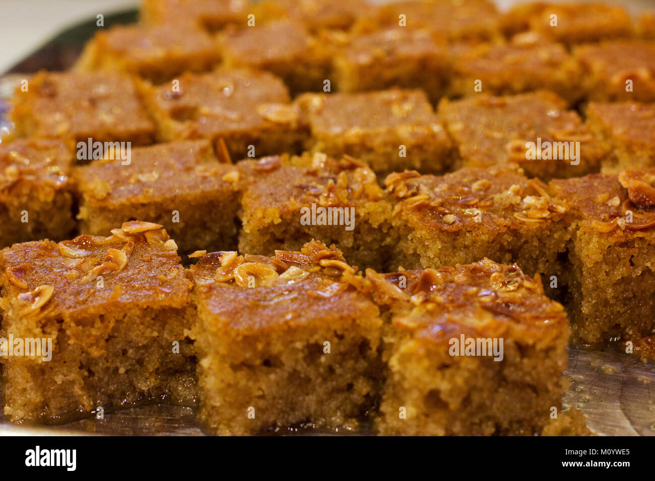 Traditional Turkish dessert Revani in the sweet sugar syrup, with nuts ...