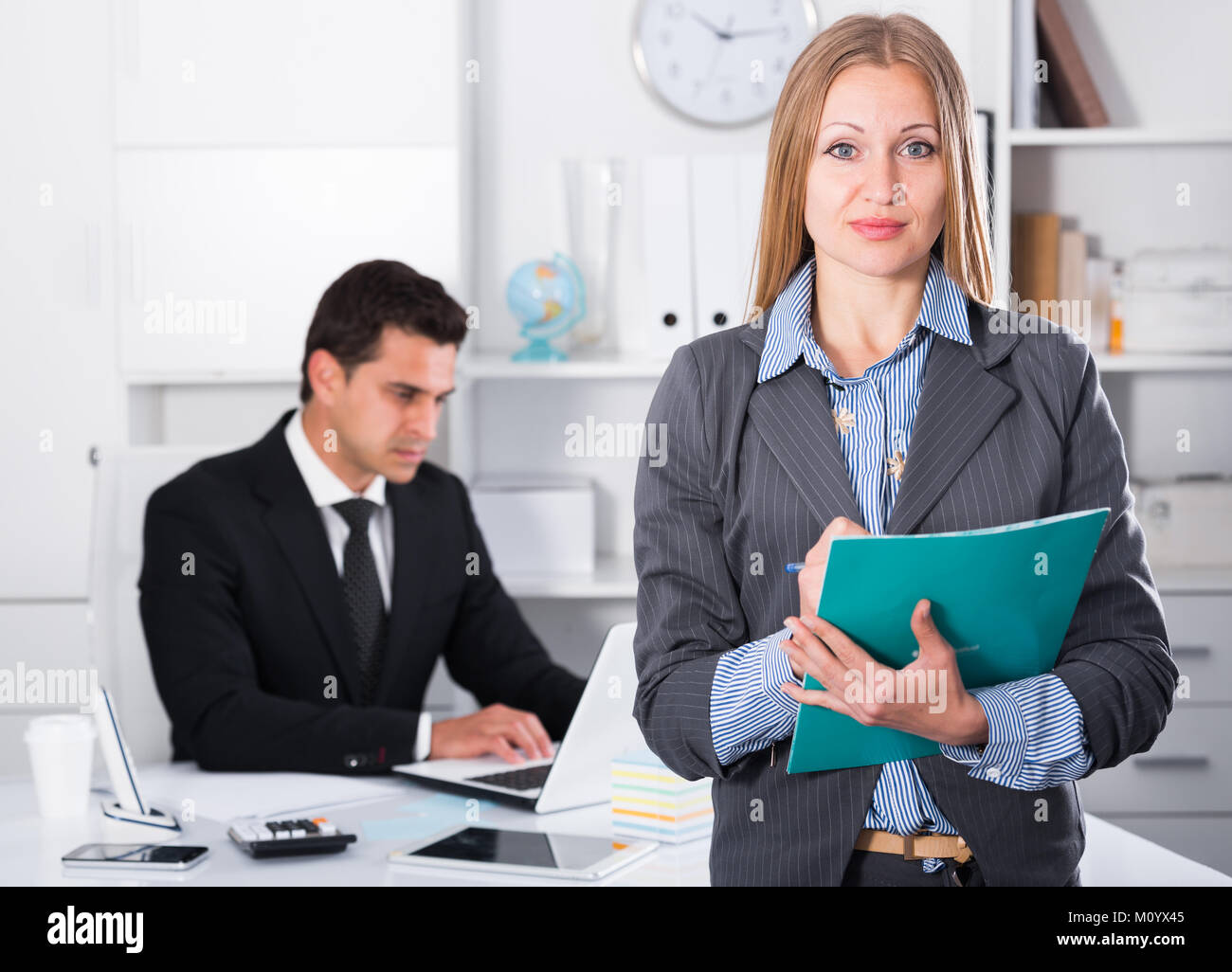 Elegant business woman writing down tasks with chief on background ...