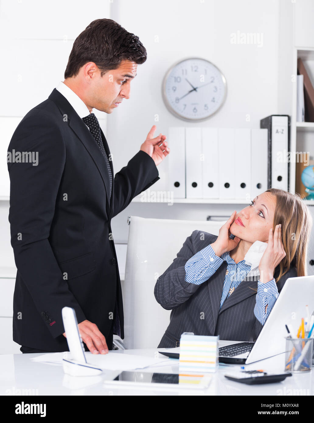 Dissatisfied manager scolding frustrated female assistant in office ...