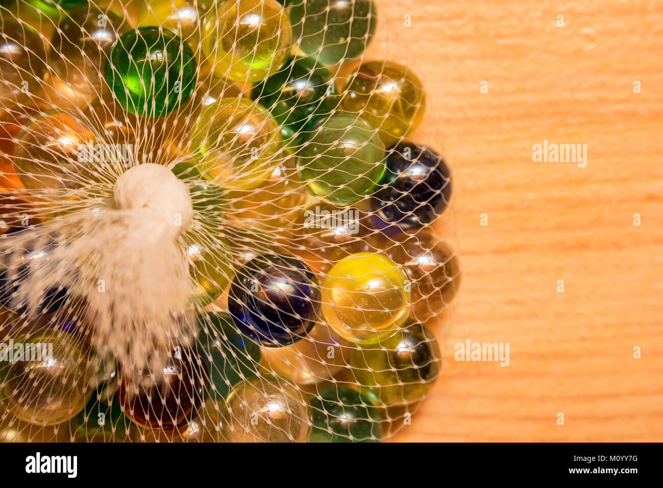 Colorful glass marbles in net Stock Photo - Alamy