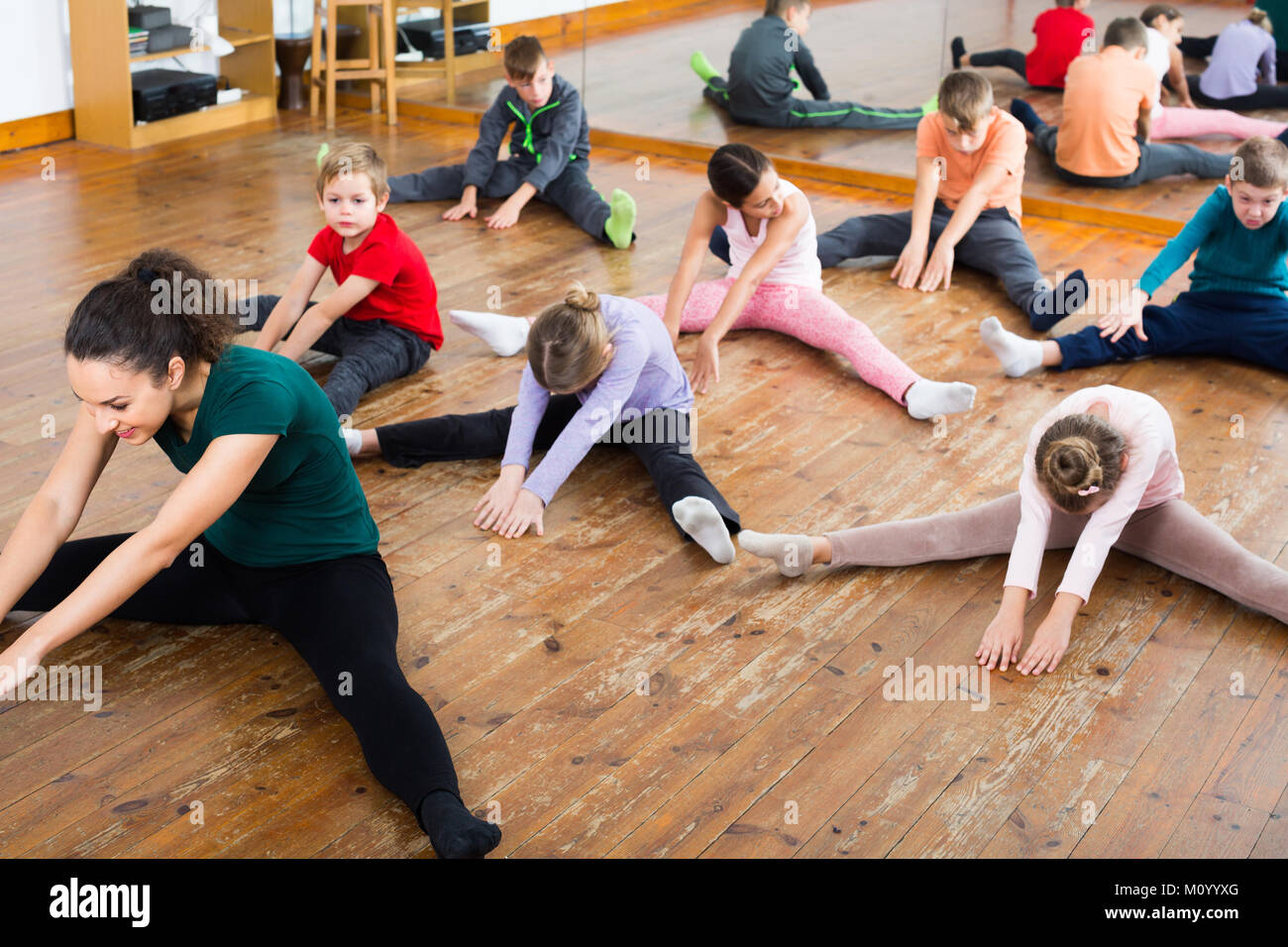 Glad children with trainer stretching in dance hall Stock Photo - Alamy