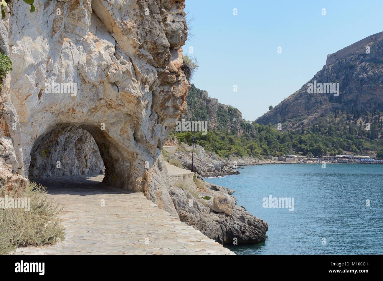 Coastal footpath and rock archway on the Acronauplia peninsula below ...