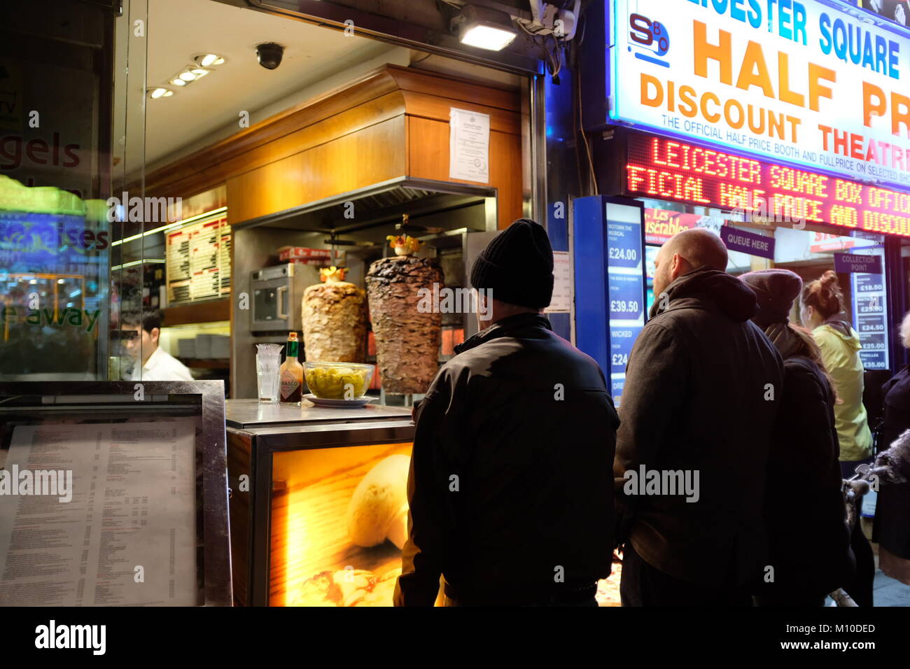men queuing for kebabs at counter, Leicester Square, London, England ...