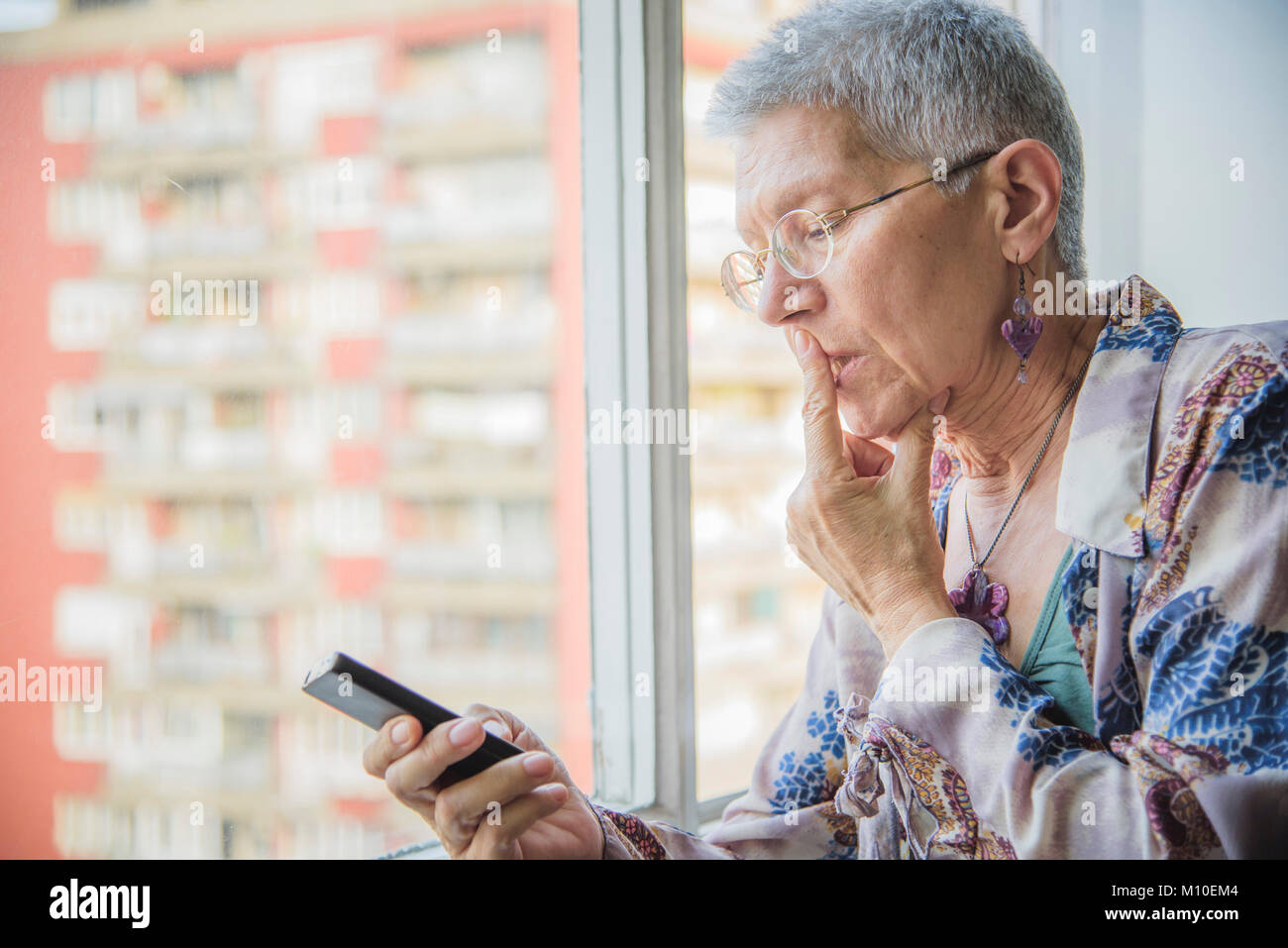 Old lady confused with her cell phone Stock Photo - Alamy