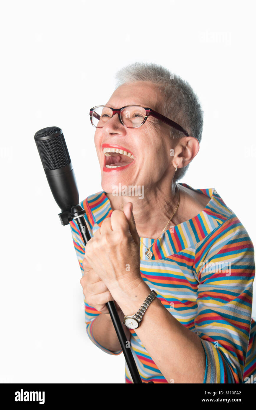 Senior old woman singing on a professional microphone Stock Photo - Alamy