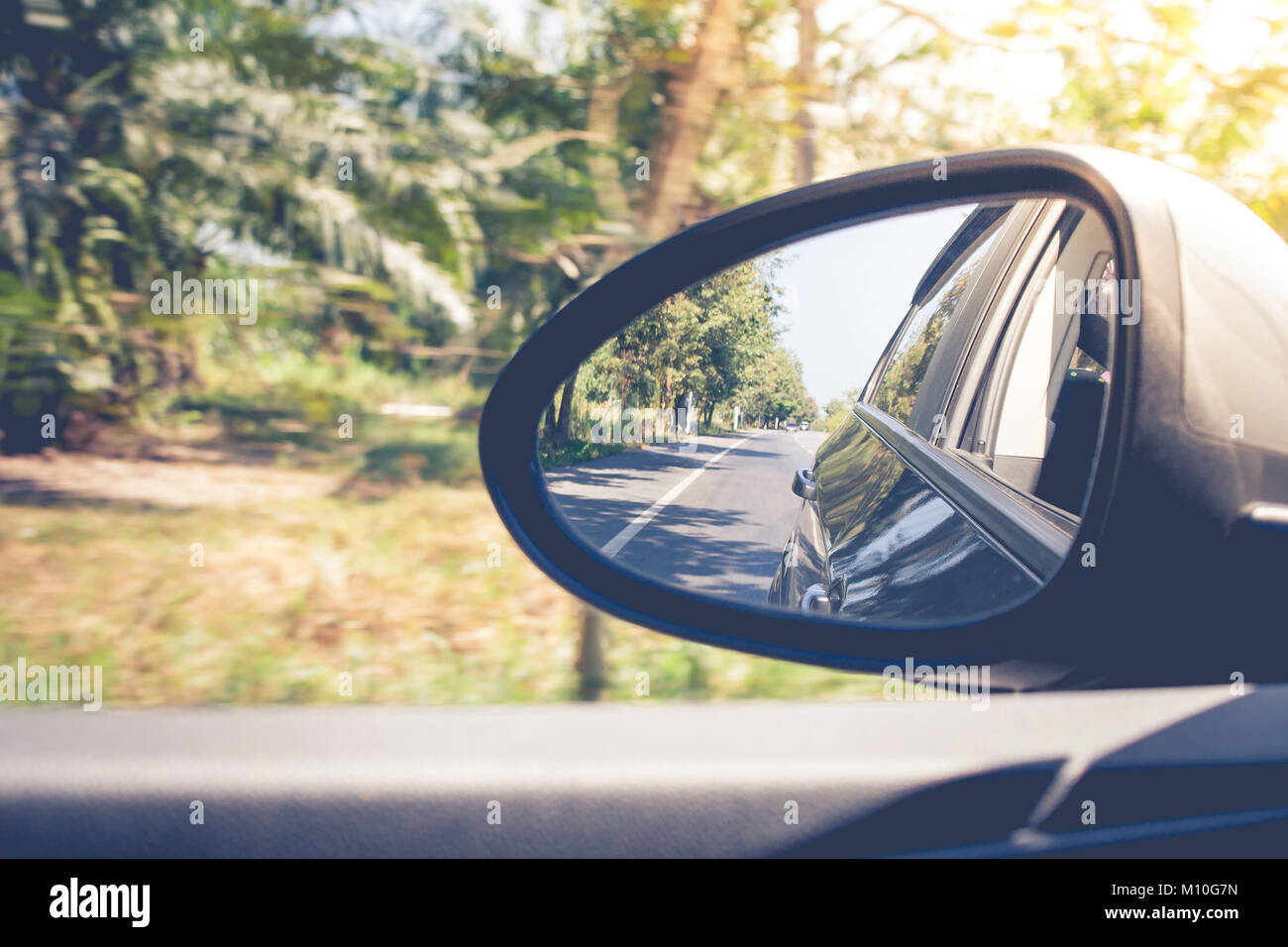 Reflection blurred roadway view on side mirror car during driving car ...