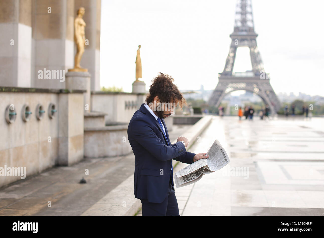 pressman reading newspaper article near Eiffel Tower Stock Photo - Alamy