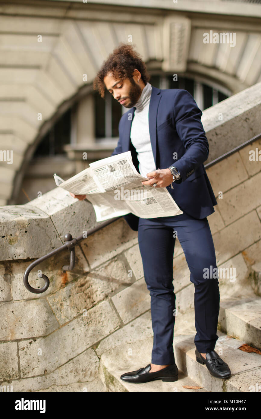 Young male model reading newspaper on open air Stock Photo - Alamy