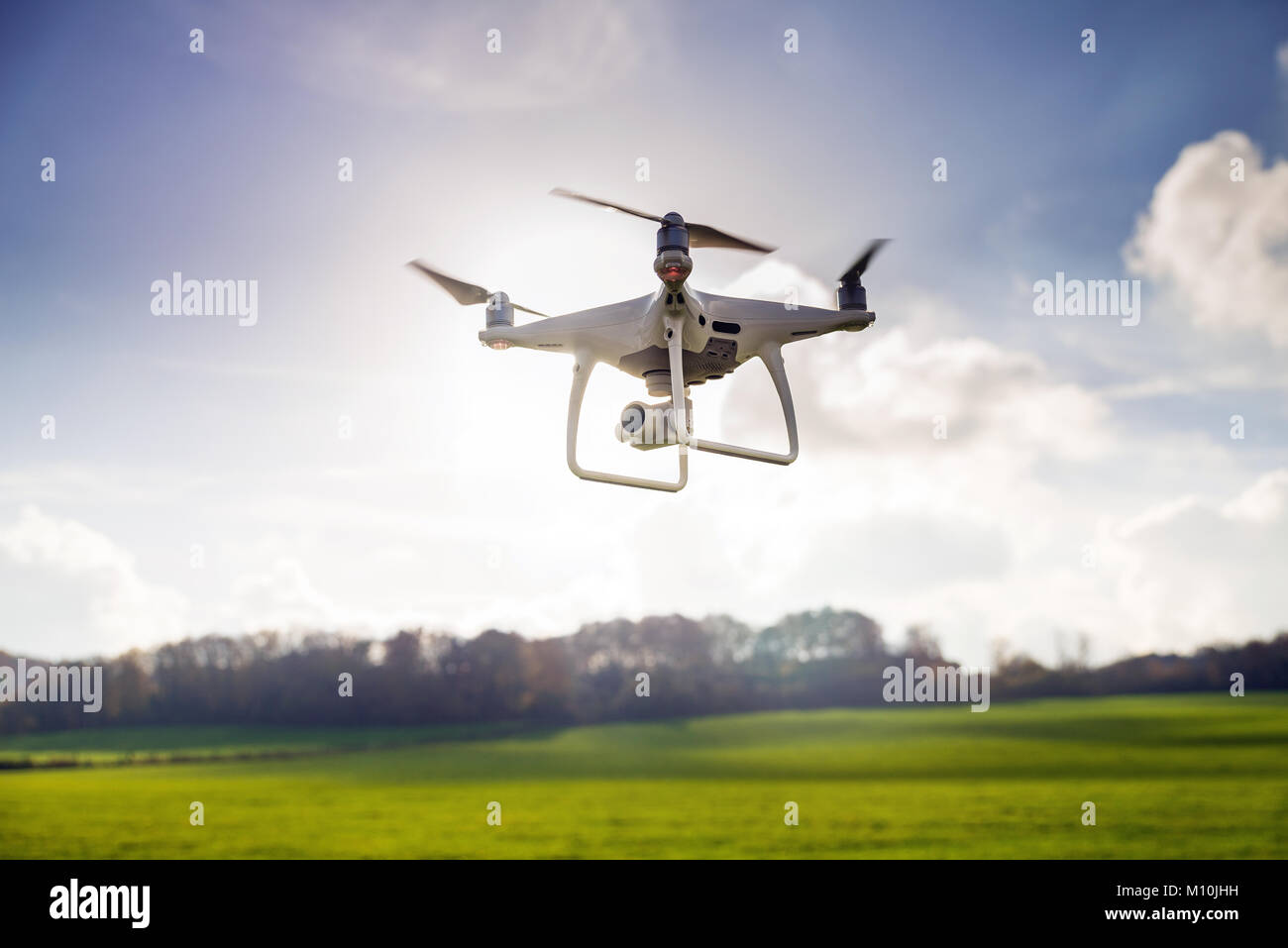 Photo of a flying white professional quadcopter drone camera in front ...