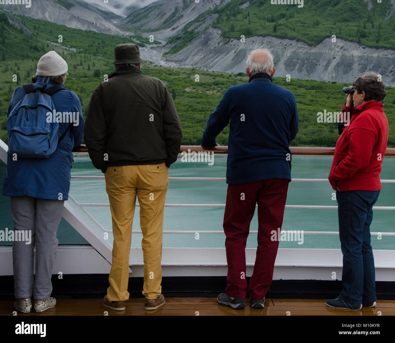 Senior citizens enjoying retirement stand by deck railing looking out ...