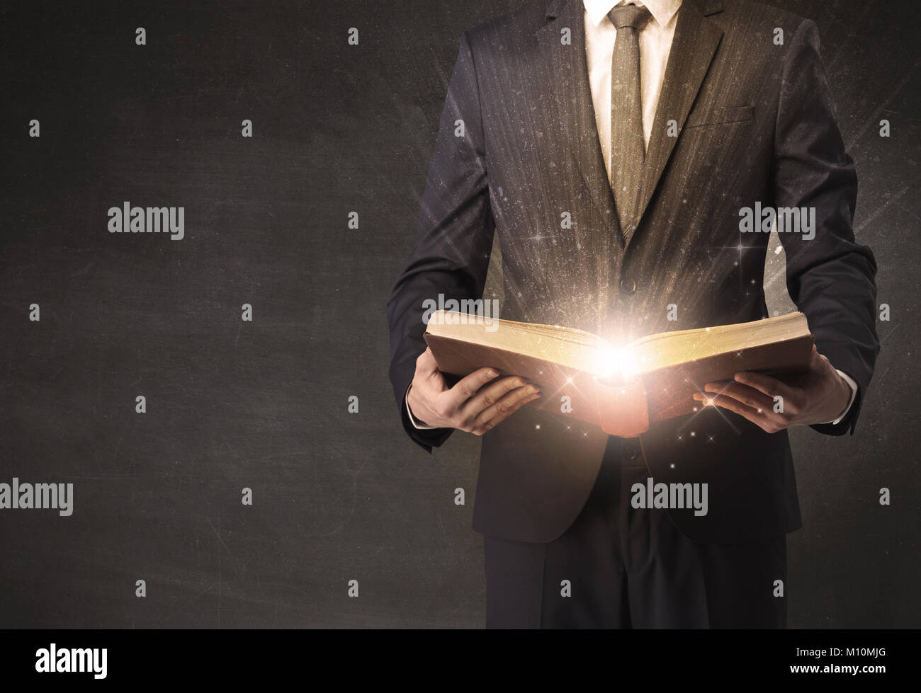 Man holding and reading a shiny book Stock Photo - Alamy