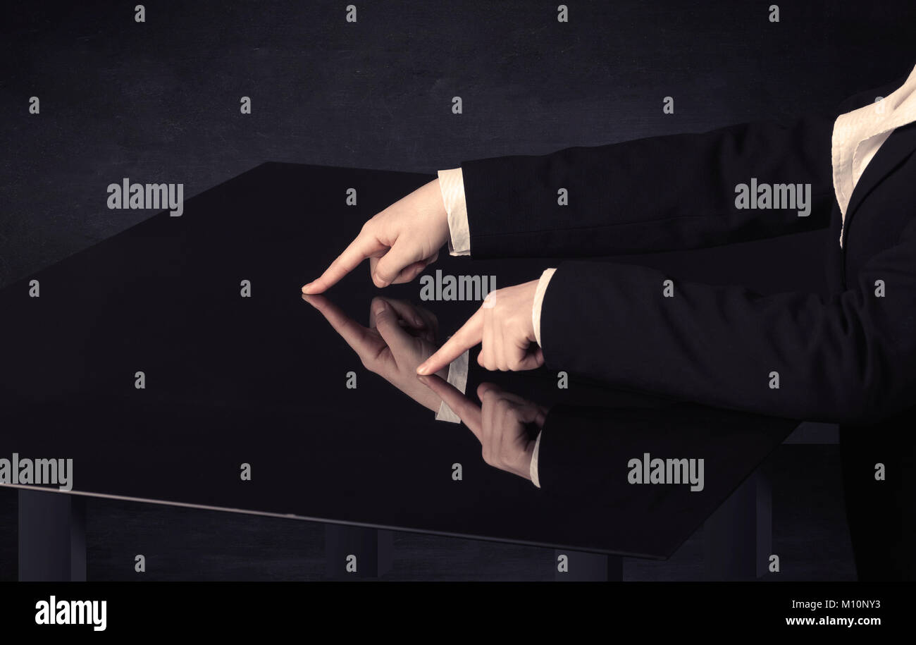 Close up of a hand touching smart table with copy space on black ...