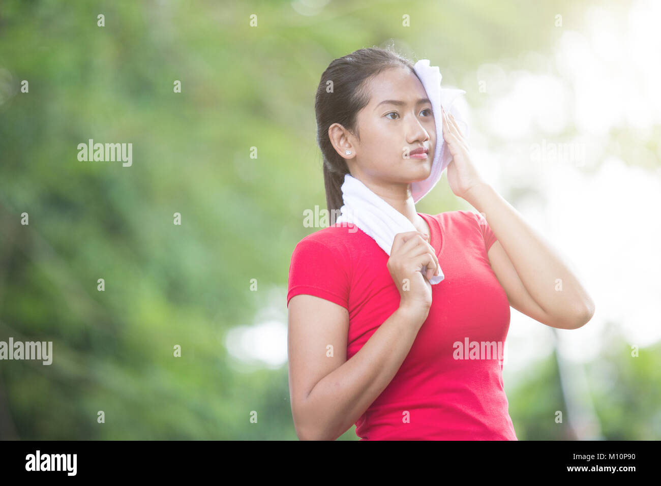 A portrait of an Asian woman wiping her sweat after exercise Stock ...
