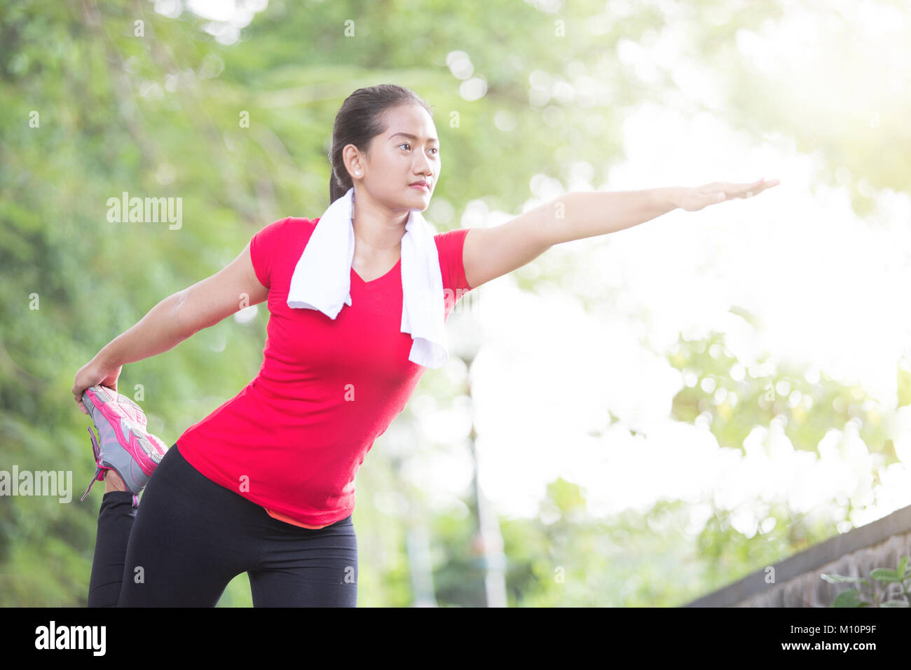 A portrait of a asian woman doing stretching exercise during outdoor ...