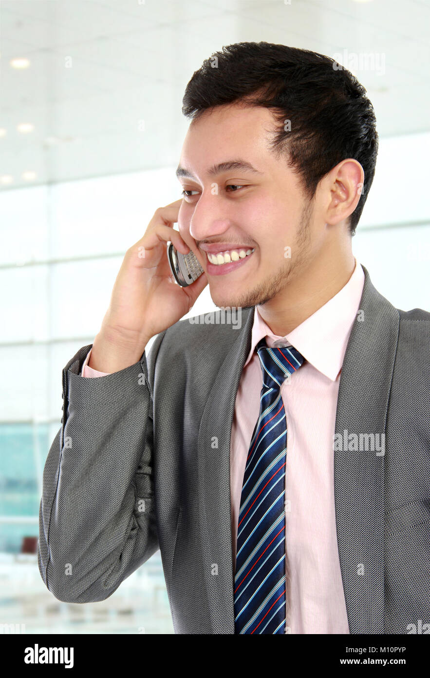 busy young business man talking on the phone isolated on white ...