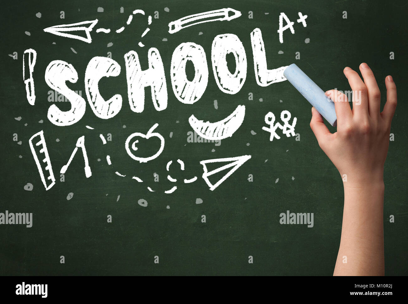 A teacher writing school, drawing children things on clean green ...