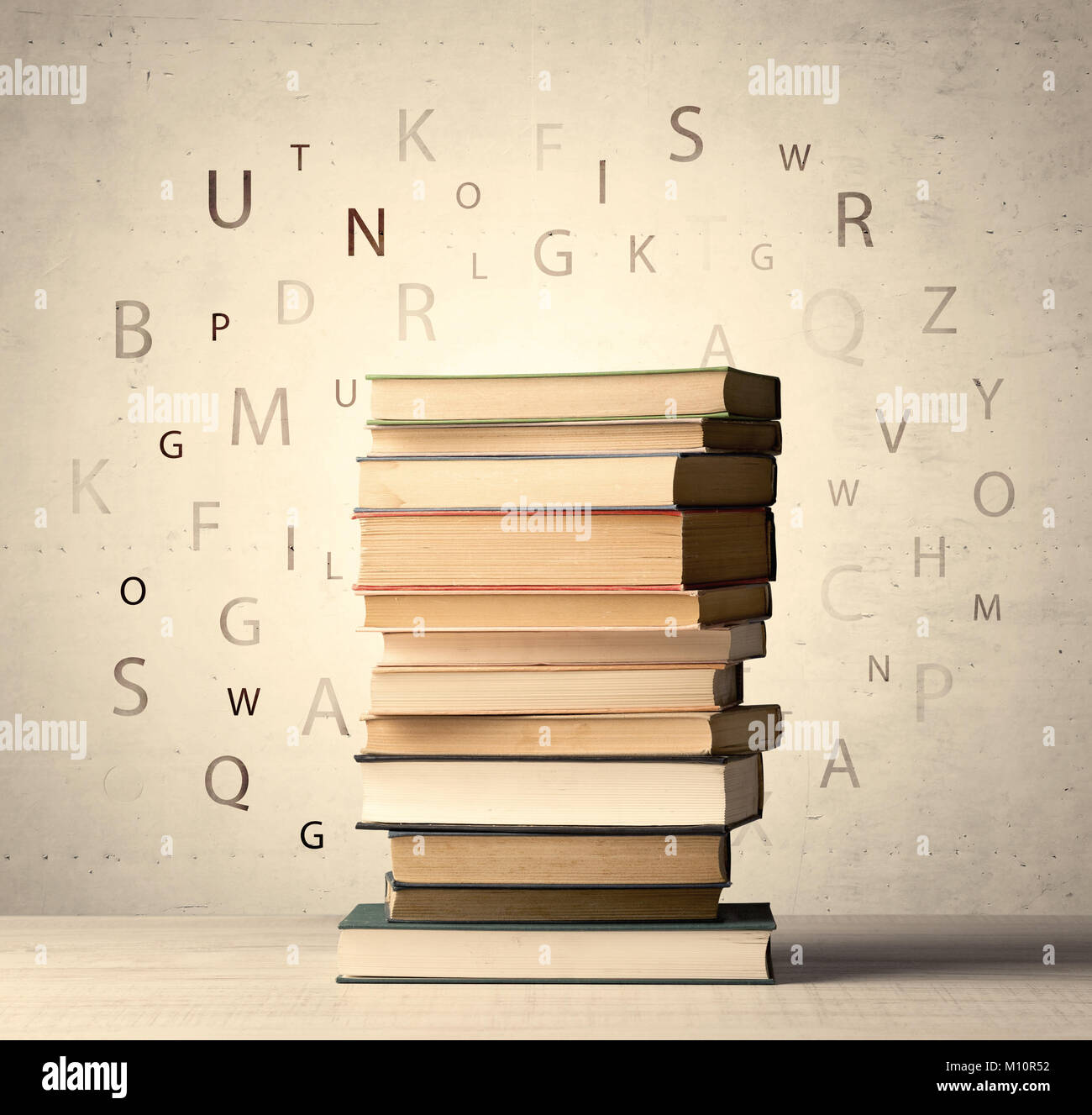Books with flying letters on vintage old background Stock Photo - Alamy