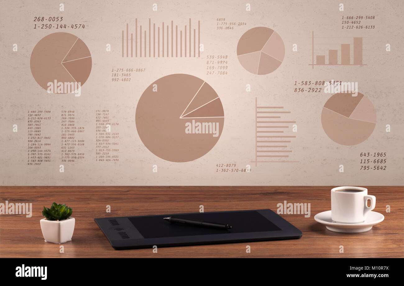 Graphic business office desk with pie charts and graphs on the brown ...