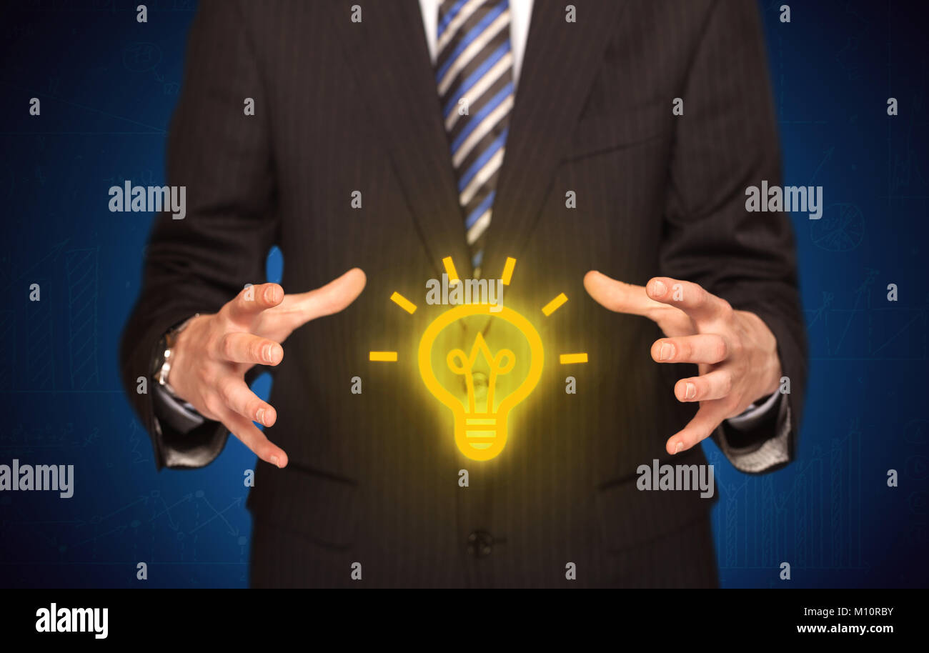 A creative businessman has a great bright idea illustrated by holding a ...