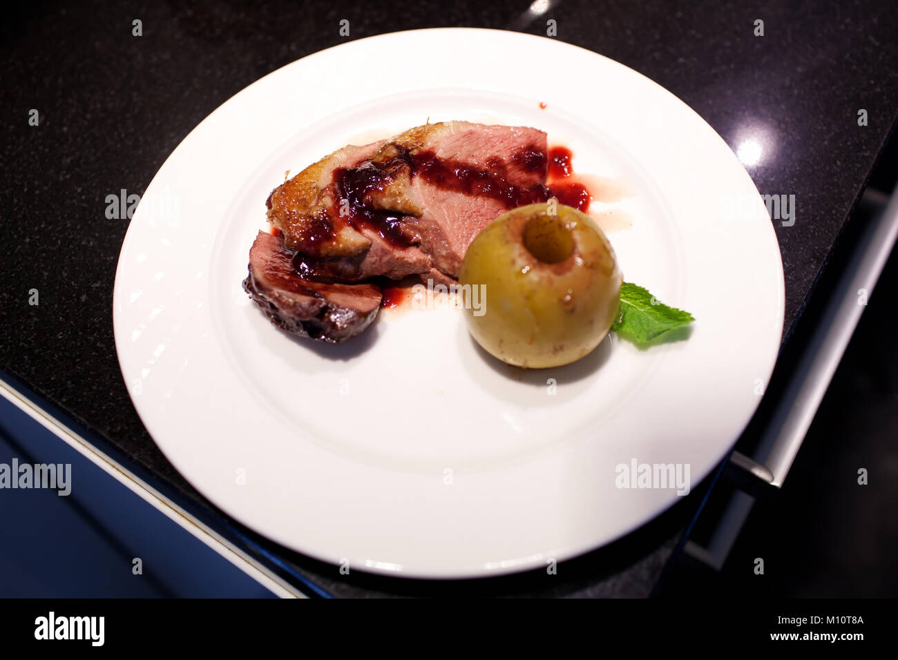 Hot meat with baked apple on the plate Stock Photo - Alamy