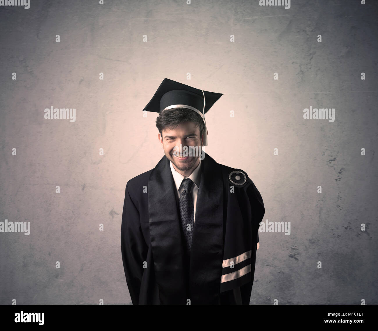 Portrait of a happy young graduate student on grungy background Stock ...