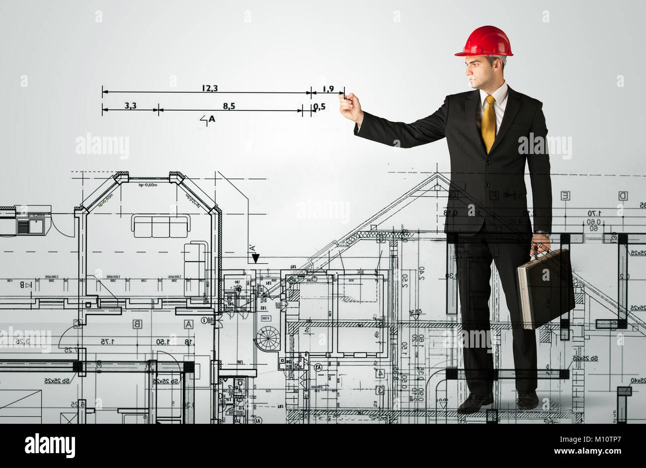 A young architect planning and drawing a family house layout with ...